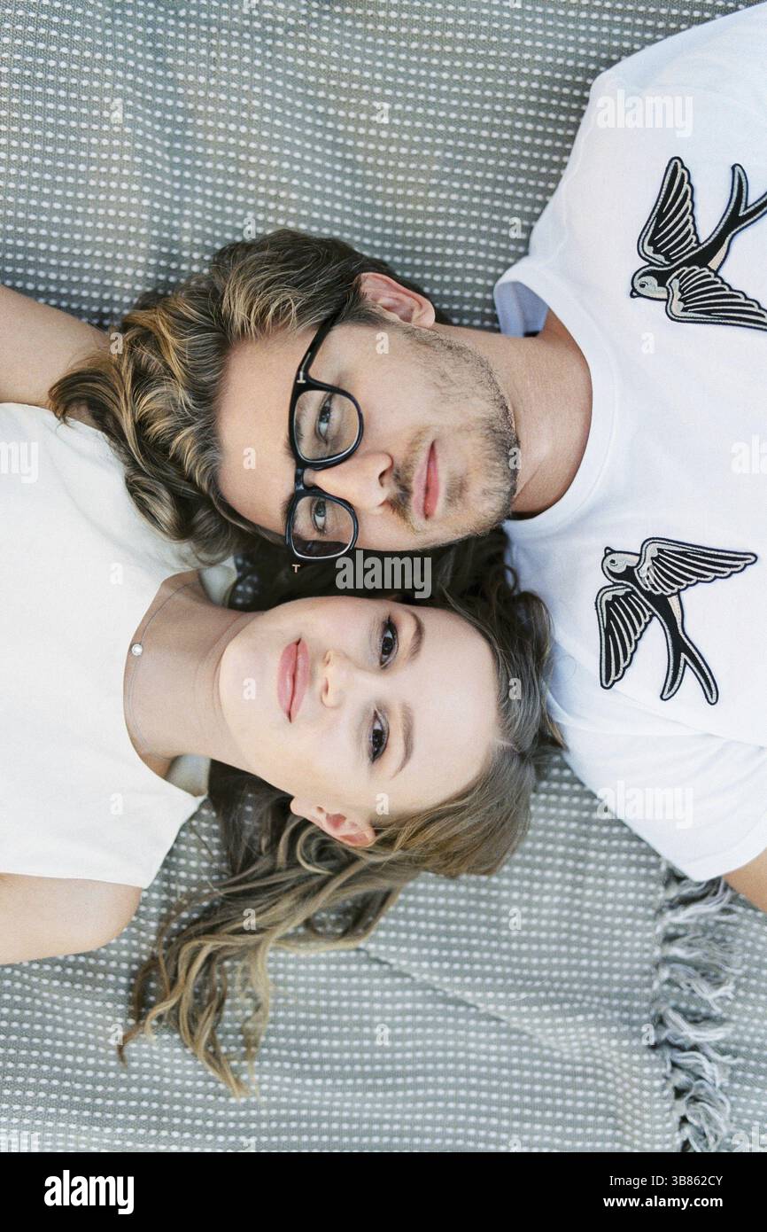 Man and woman lie head to head on a blanket. Top view Stock Photo - Alamy