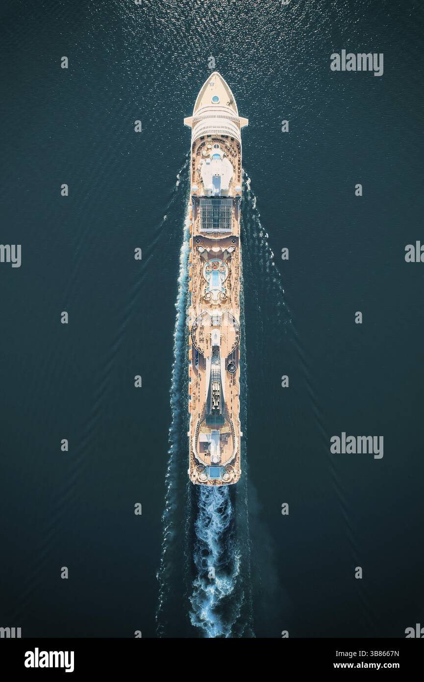 Huge cruise ship with a swimming pools floats on the sea. Top view ...