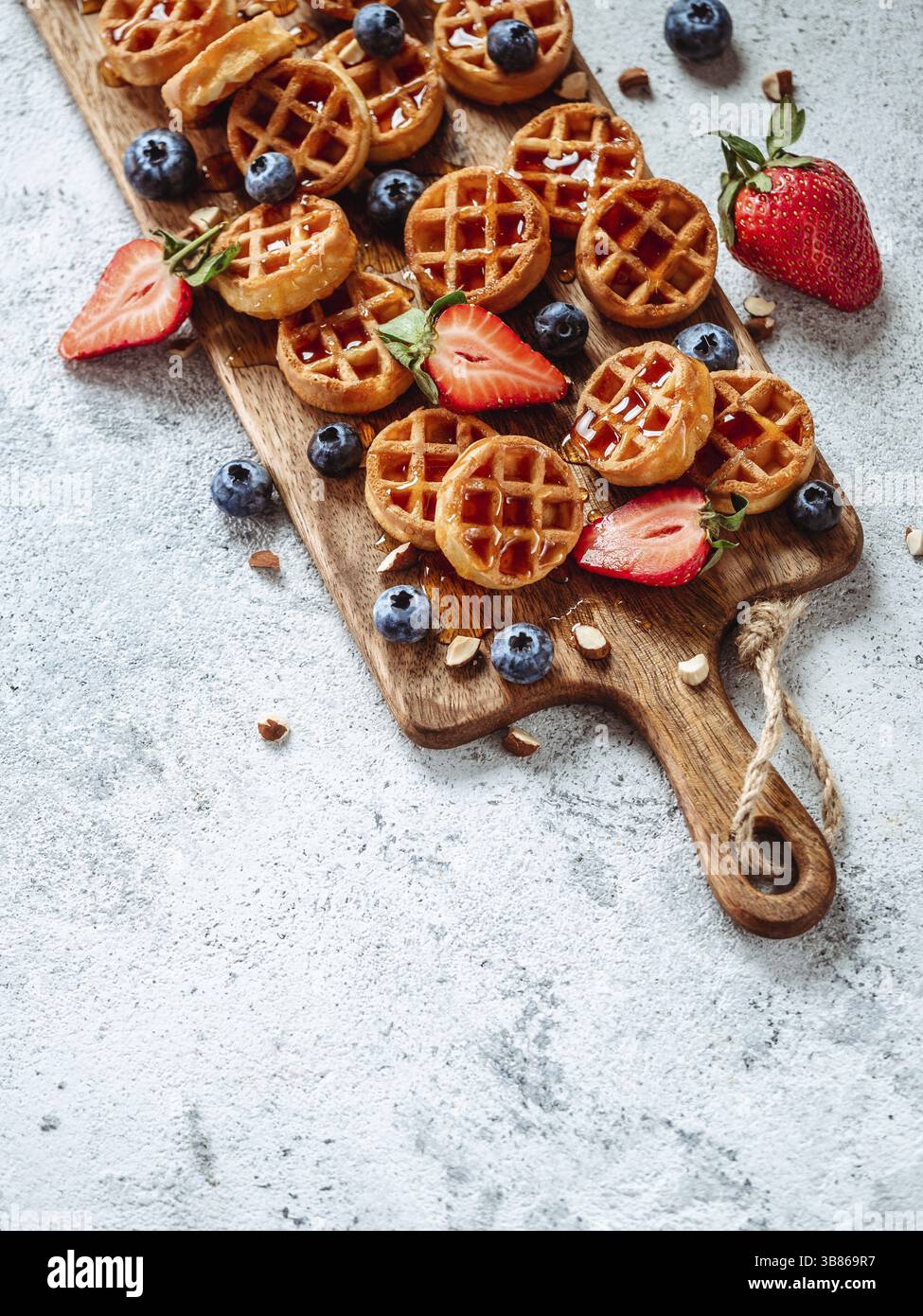 Small round delicious soft belgian waffles on cutting board. Fresh ...