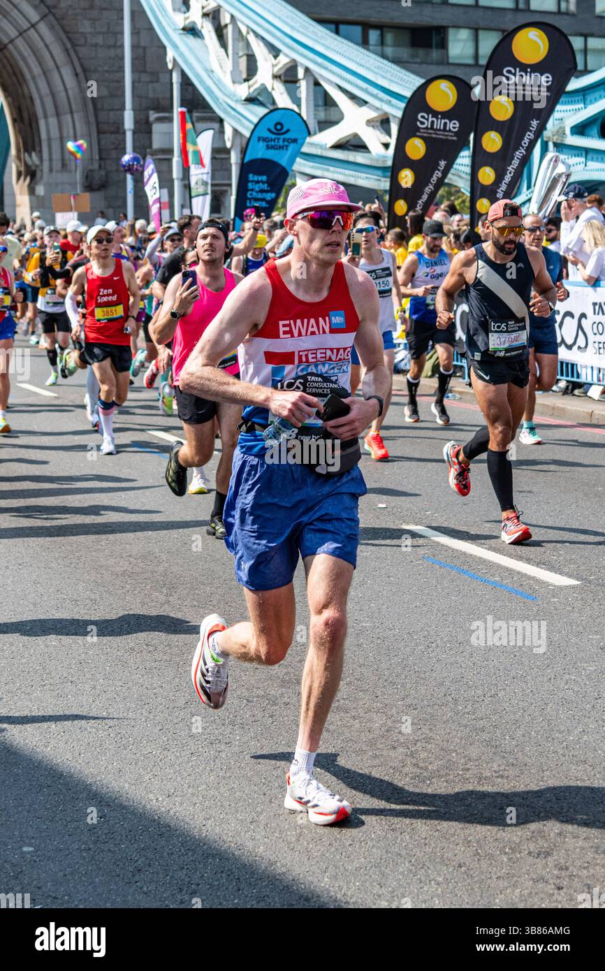 Runners running at the London Marathon 2025 for Teenage Cancer Trust charity on Tower Bridge in ...