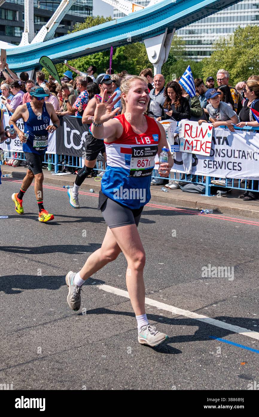 Runners running at the London Marathon 2025 for Teenage Cancer Trust charity on Tower Bridge in ...
