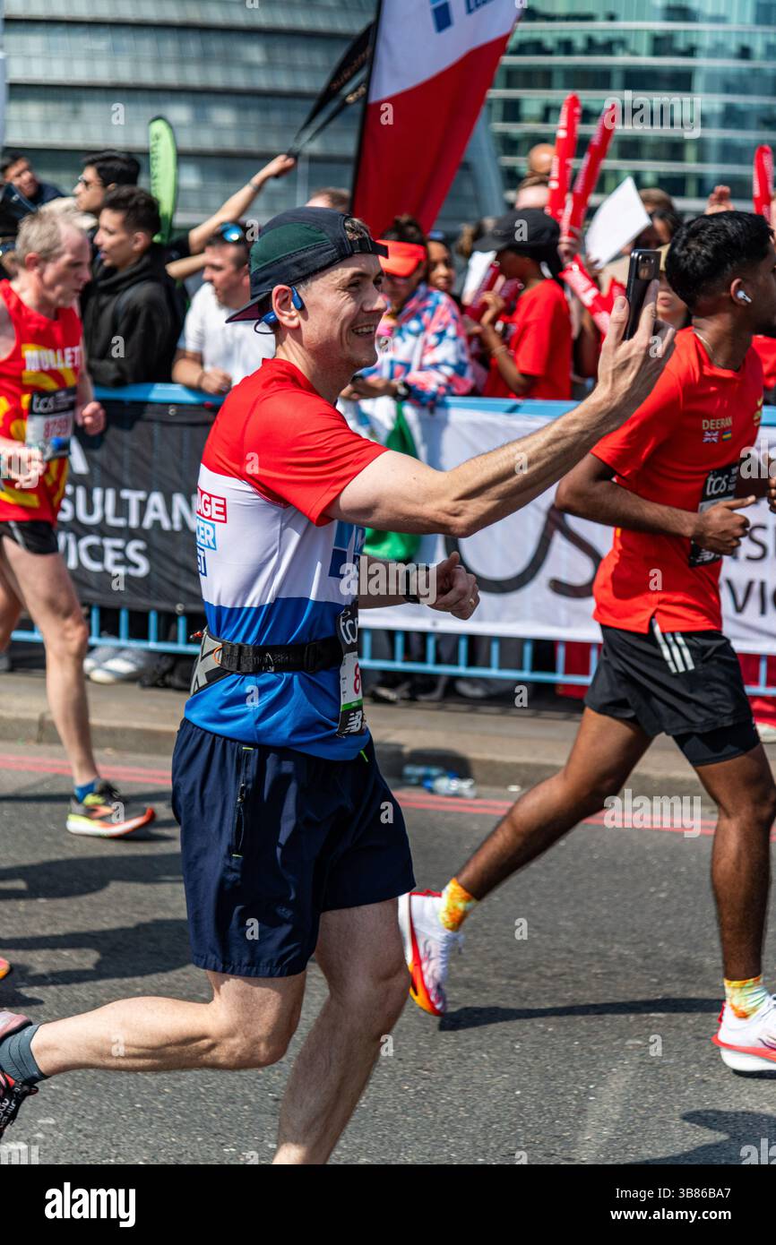A runner taking a selfie whilst running at the London Marathon 2025 for ...