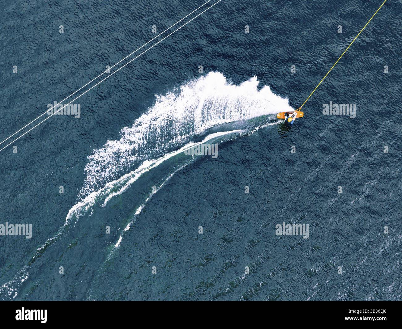 Aerial wakeboarding. Top view of awakeboard rider in wake cable park ...