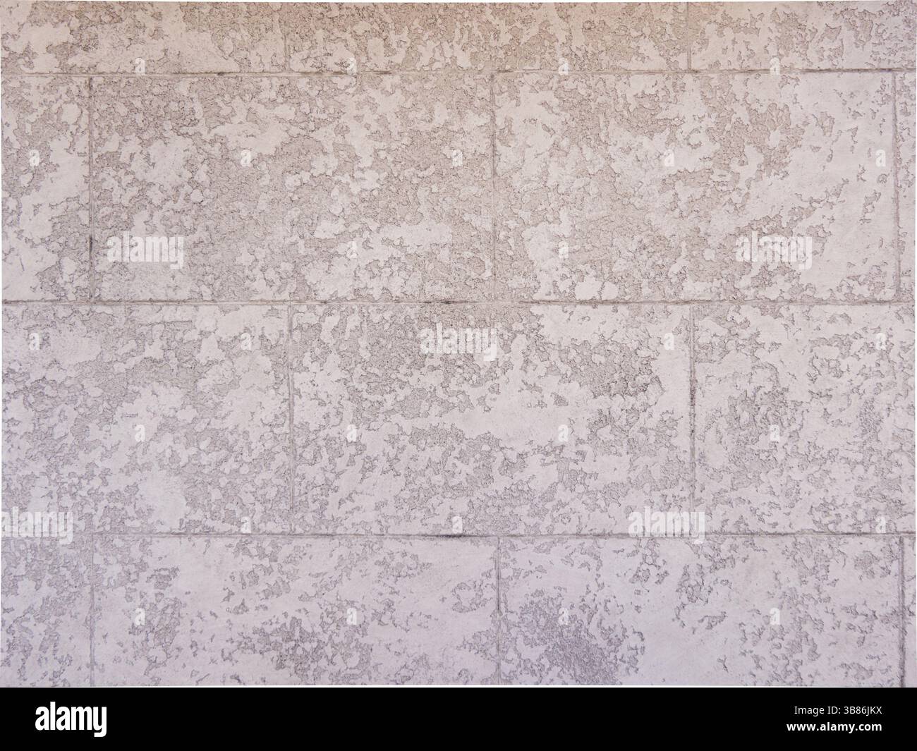 A wall from an artificial gray stone facade with rough fractured surfaces, laid as a brick Stock ...