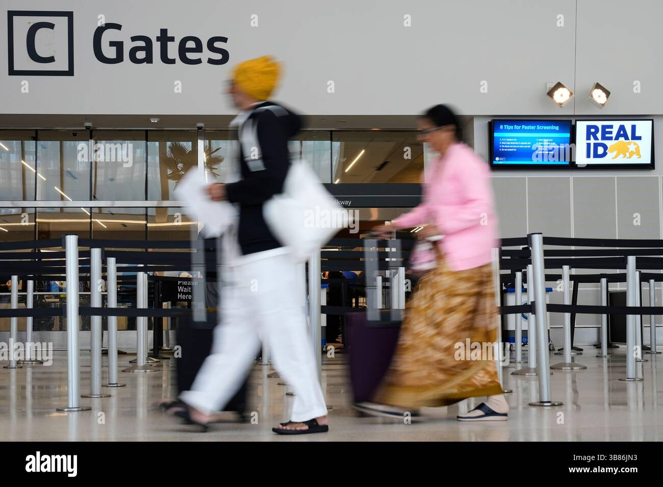 Travelers enter the security checkpoint line in a domestic terminal at ...