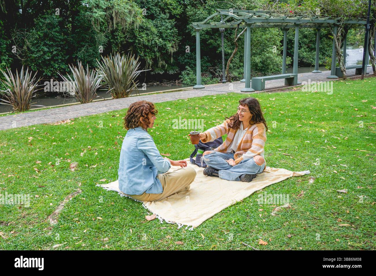 Mother and daughter enjoying mate together on the grass Stock Photo - Alamy