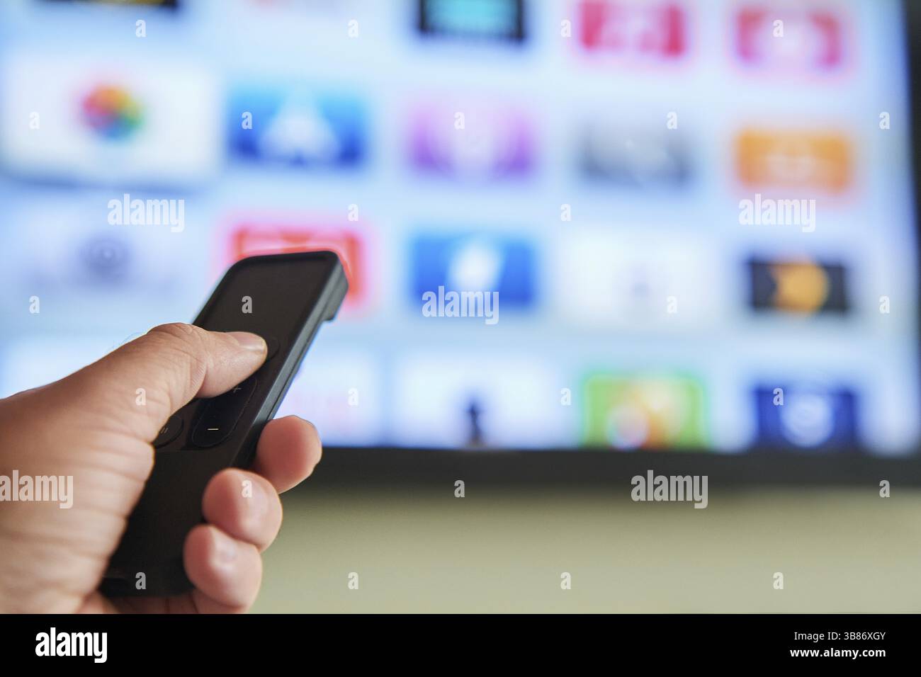 Multimedia streaming concept. Hand holding remote control. TV screen ...