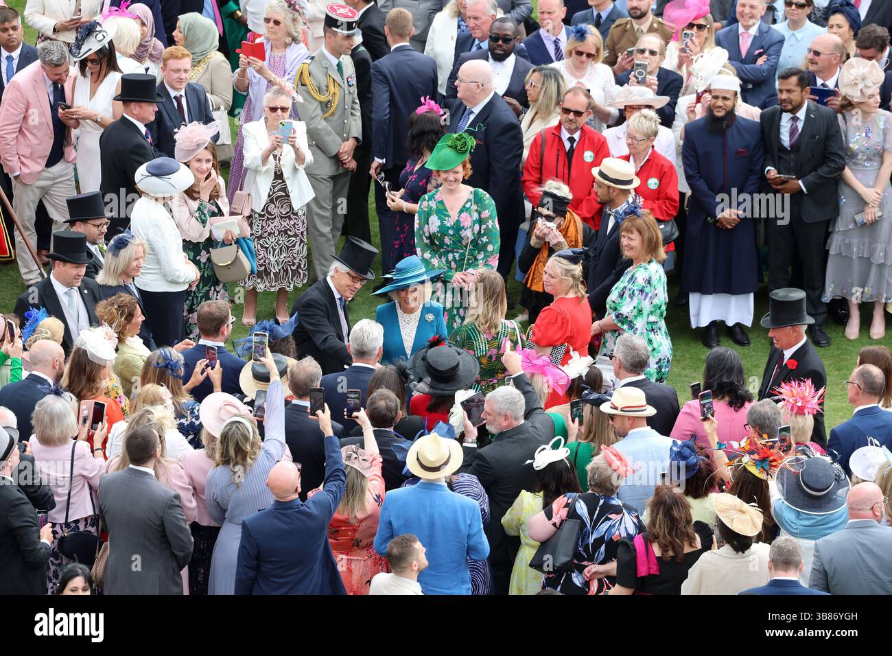 Queen Camilla (centre facing) meets guests attending a Royal Garden ...