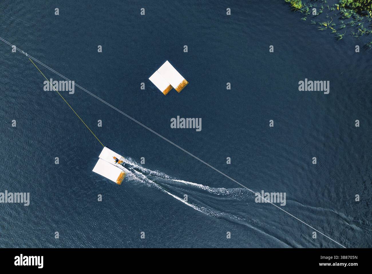 Aerial wakeboarding. Top view of awakeboard rider in wake cable park ...