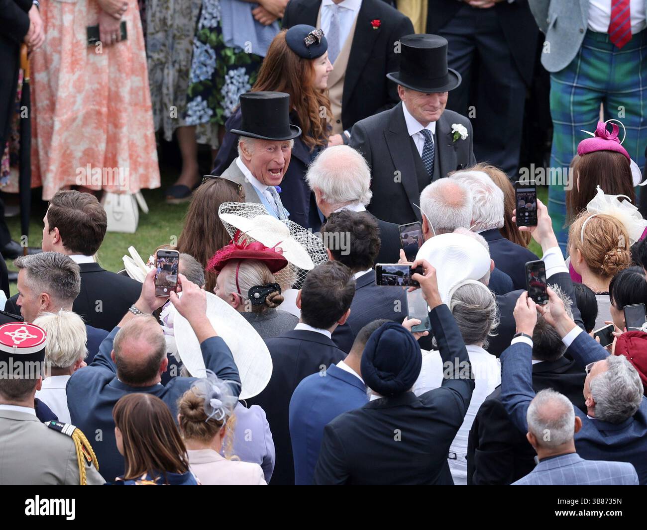 Britain's King Charles III laughs with guests during a garden party, at ...