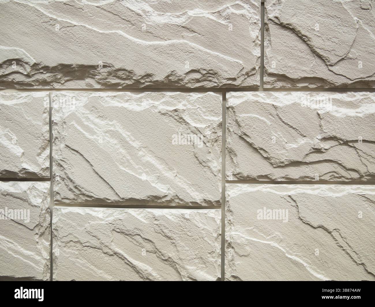 A wall from an artificial gray stone facade with rough fractured ...