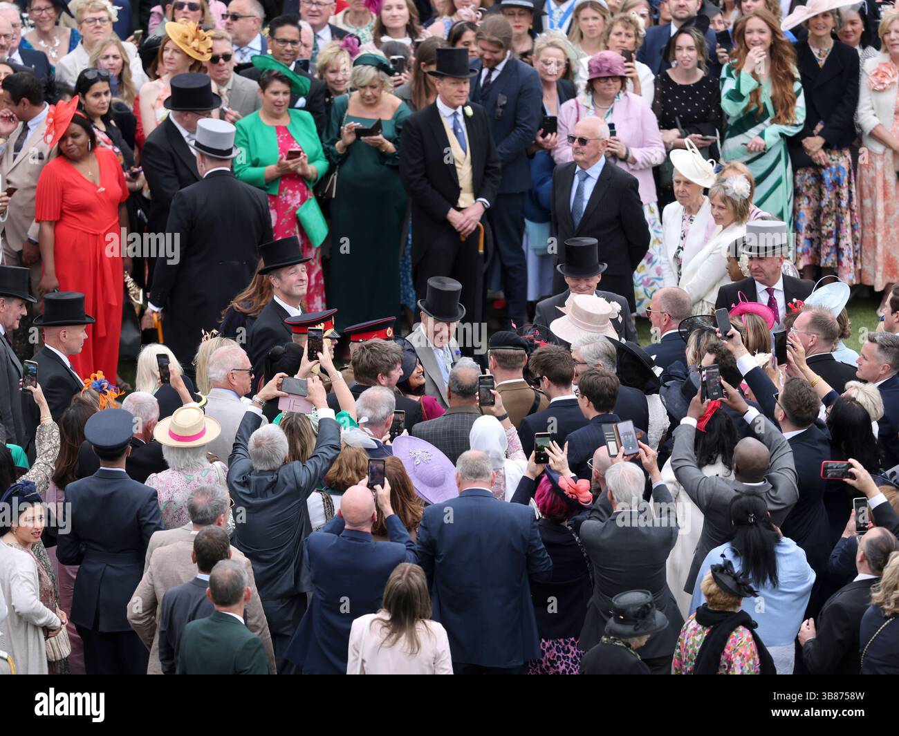 Britain's King Charles III, center, laughs with guests during a garden ...
