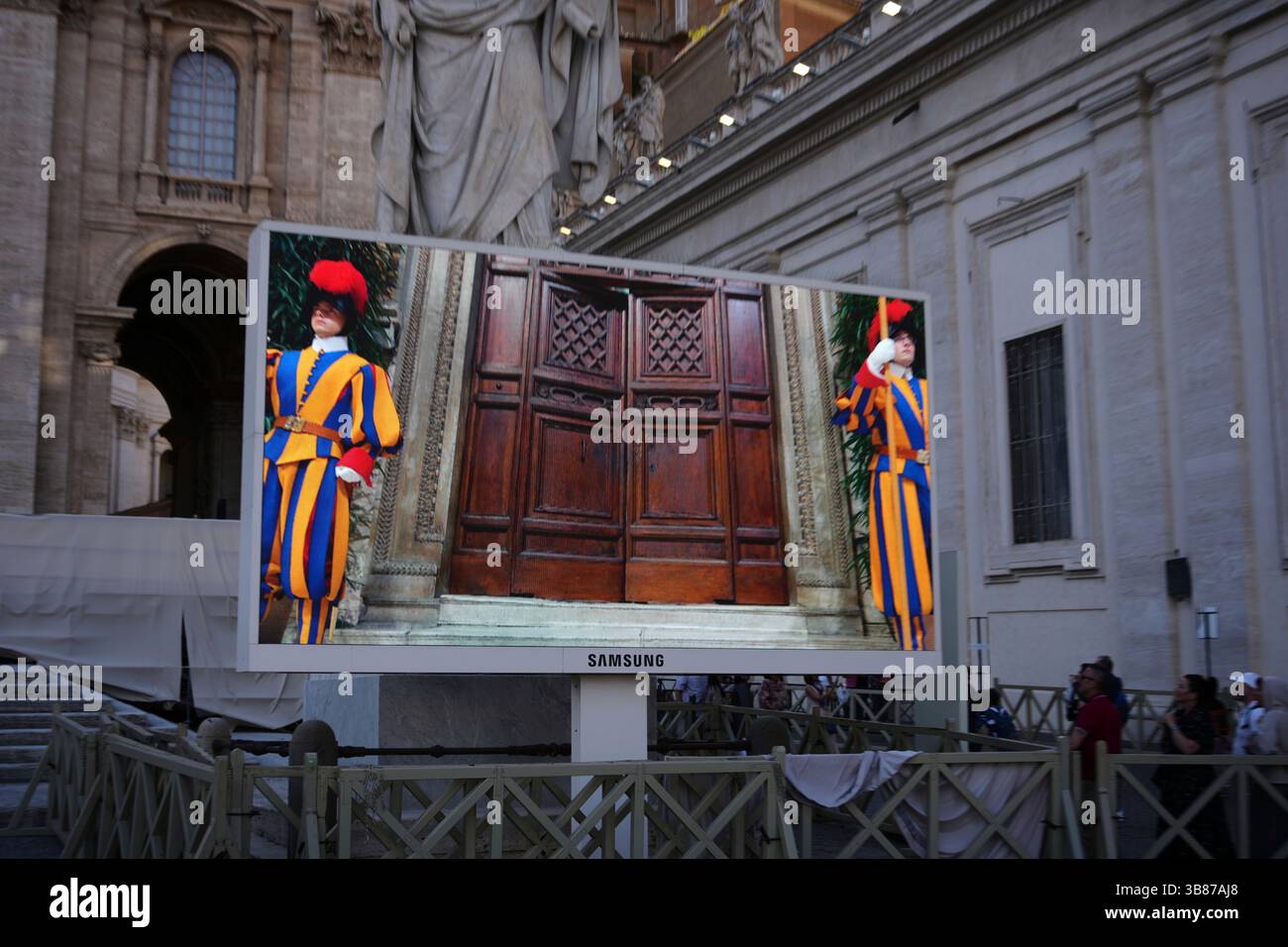 A giant screen shows Swiss Guards standing as the door of the Sistine Chapel is being closed ...