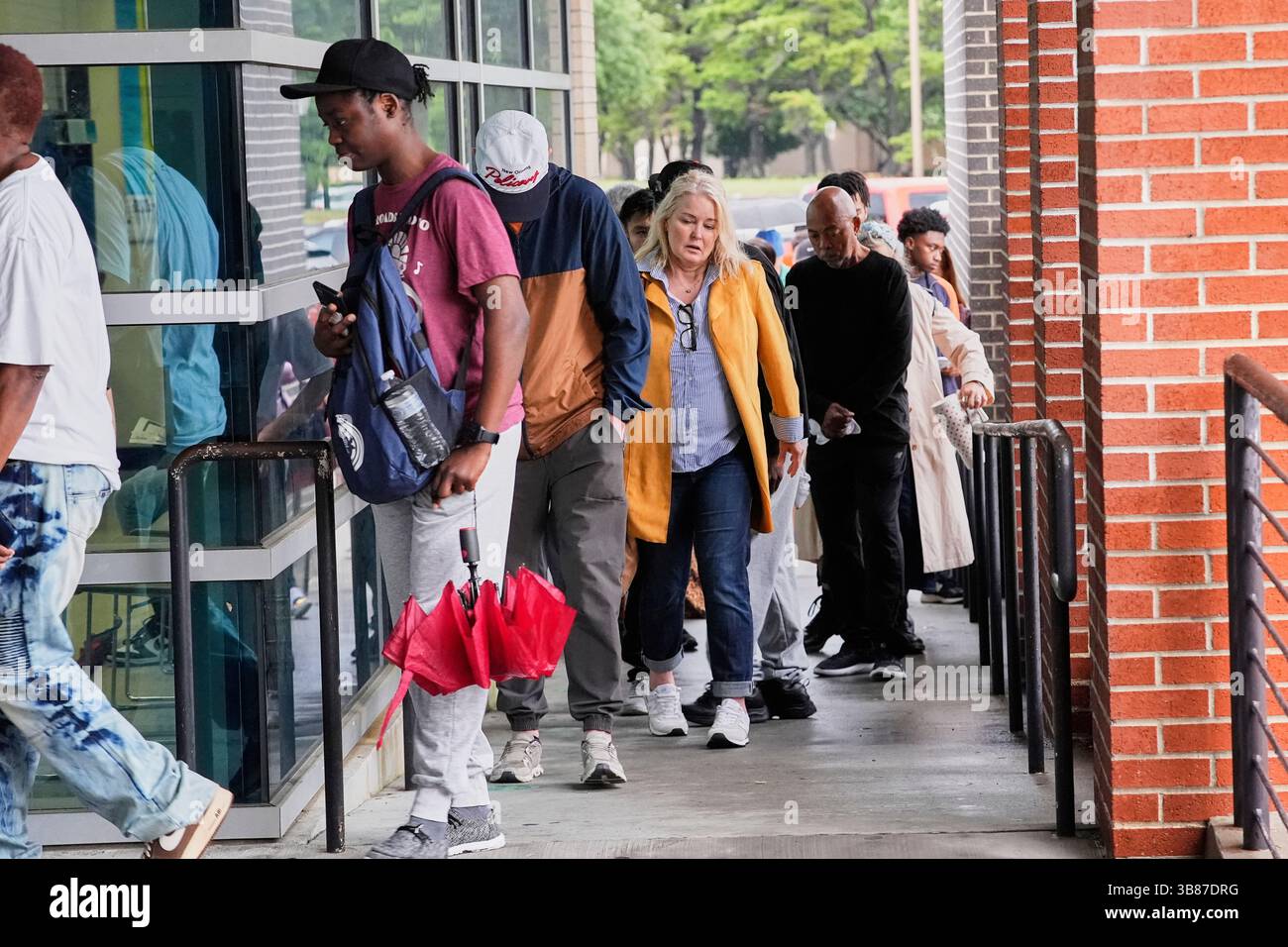 People wait outside a branch of the Louisiana Office of Motor Vehicles ...