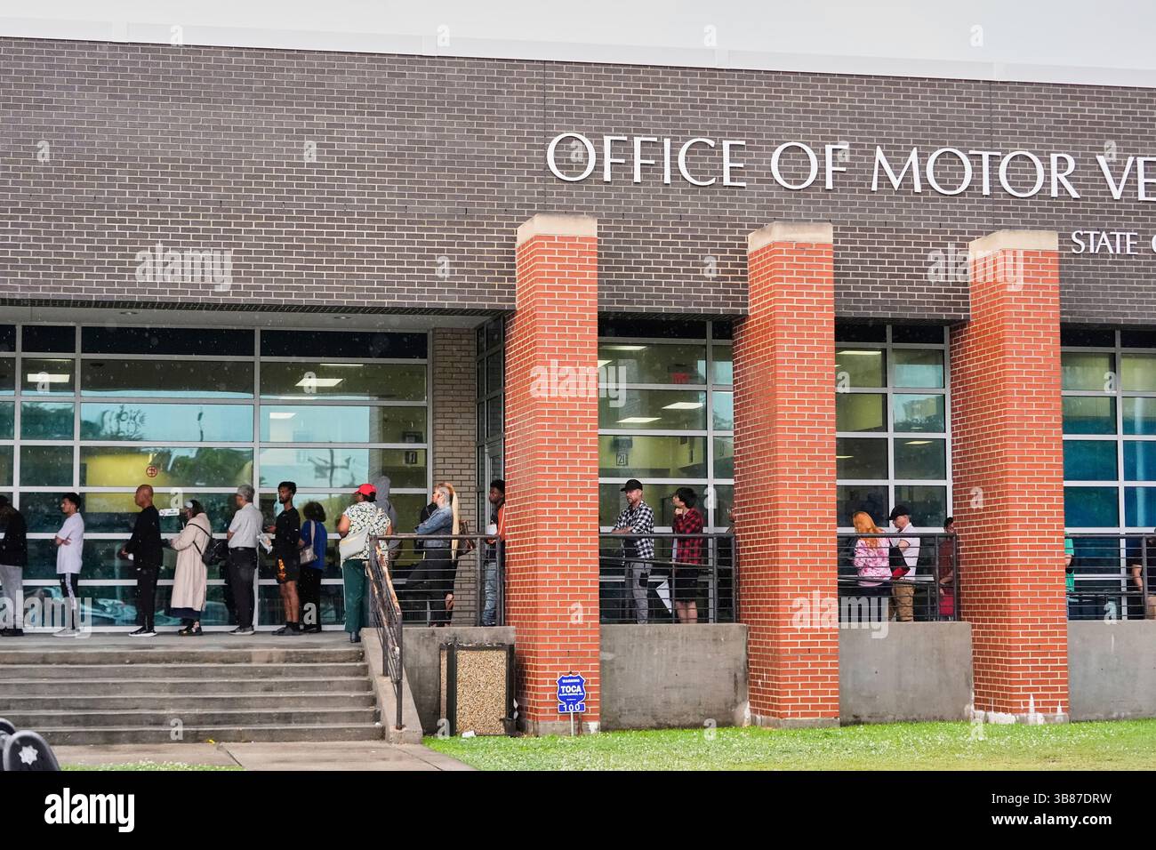 People wait outside a branch of the Louisiana Office of Motor Vehicles ...
