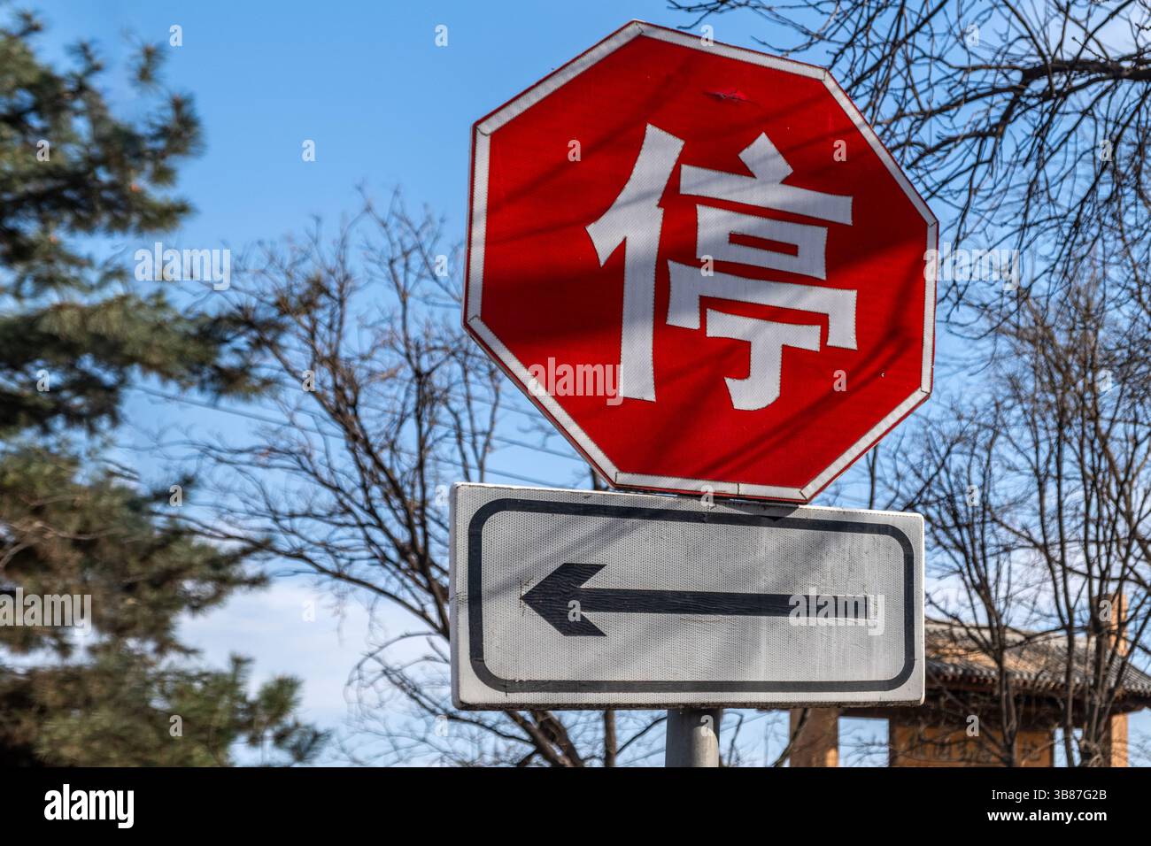 Stop road sign in chinese language and left pointing arrow. Traffic ...