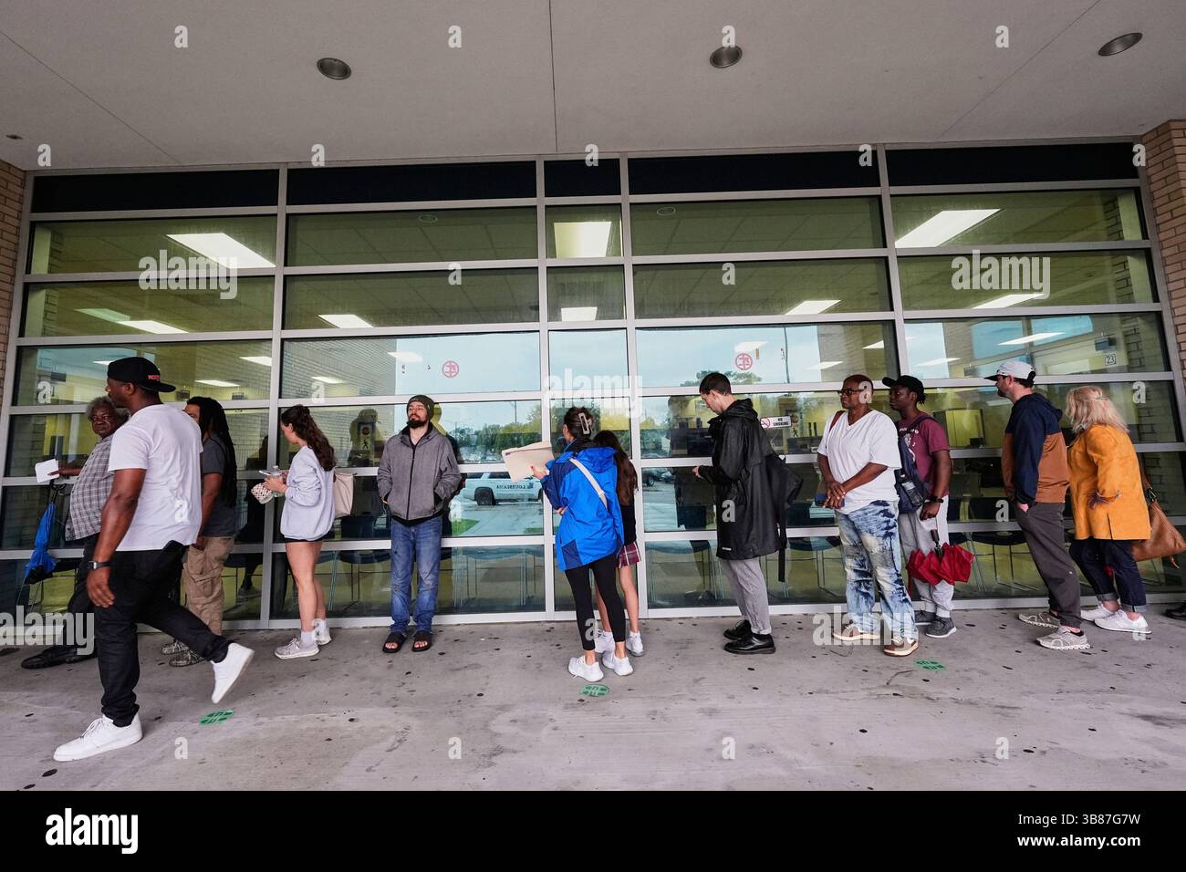 People wait outside a branch of the Louisiana Office of Motor Vehicles ...