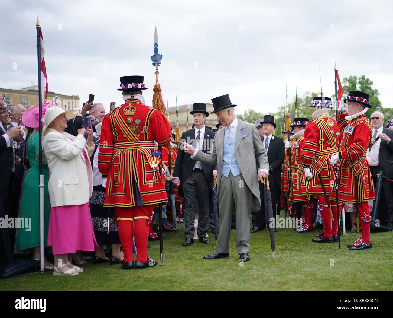 King Charles III speaks to guests during a Royal Garden Party at ...