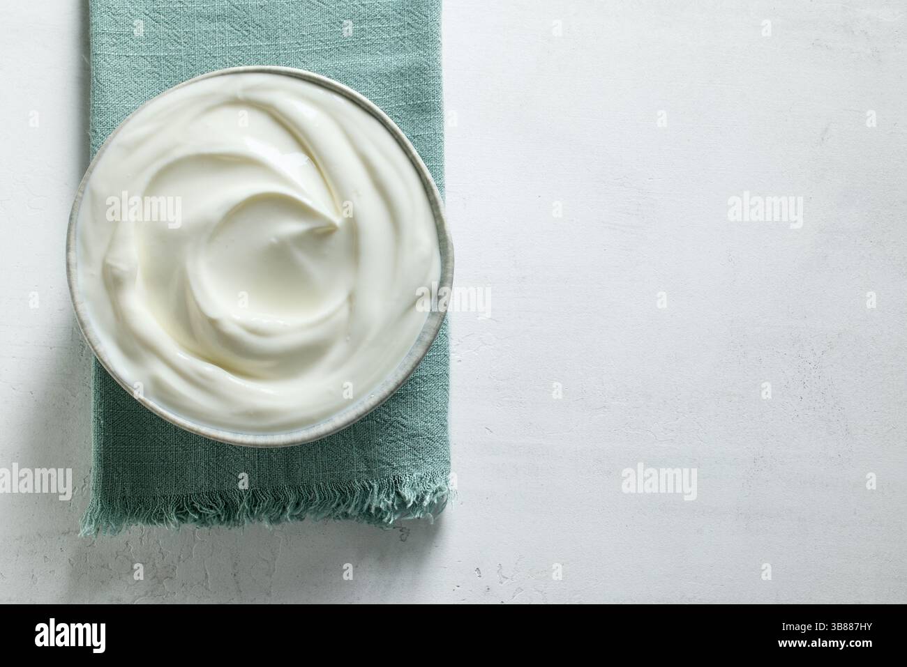 bowl of sour cream yogurt on white kitchen table, top view Stock Photo ...