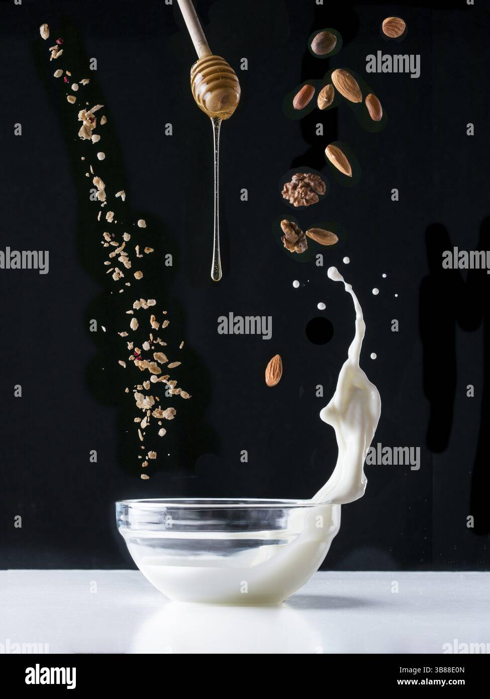 Falling granola with milk splash, falling nuts and honey flows from ...