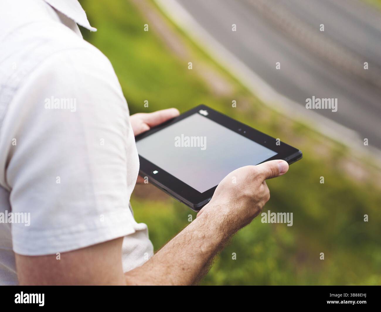 Smart casual man with digital tablet outdoors, close up. Focus on ...