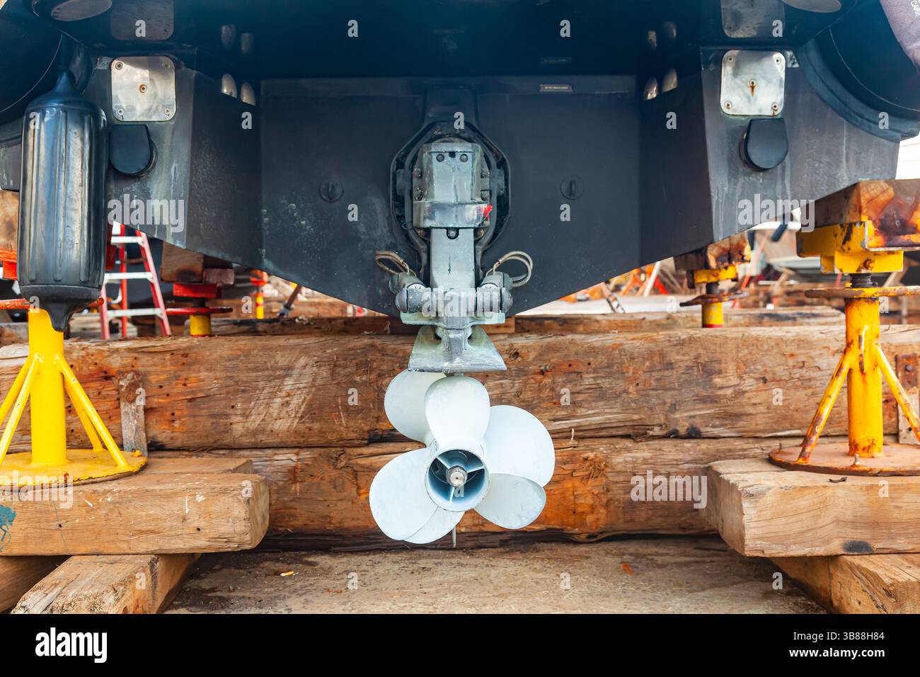 The back of a motor yacht dry docked on wooden blocks and supported by ...