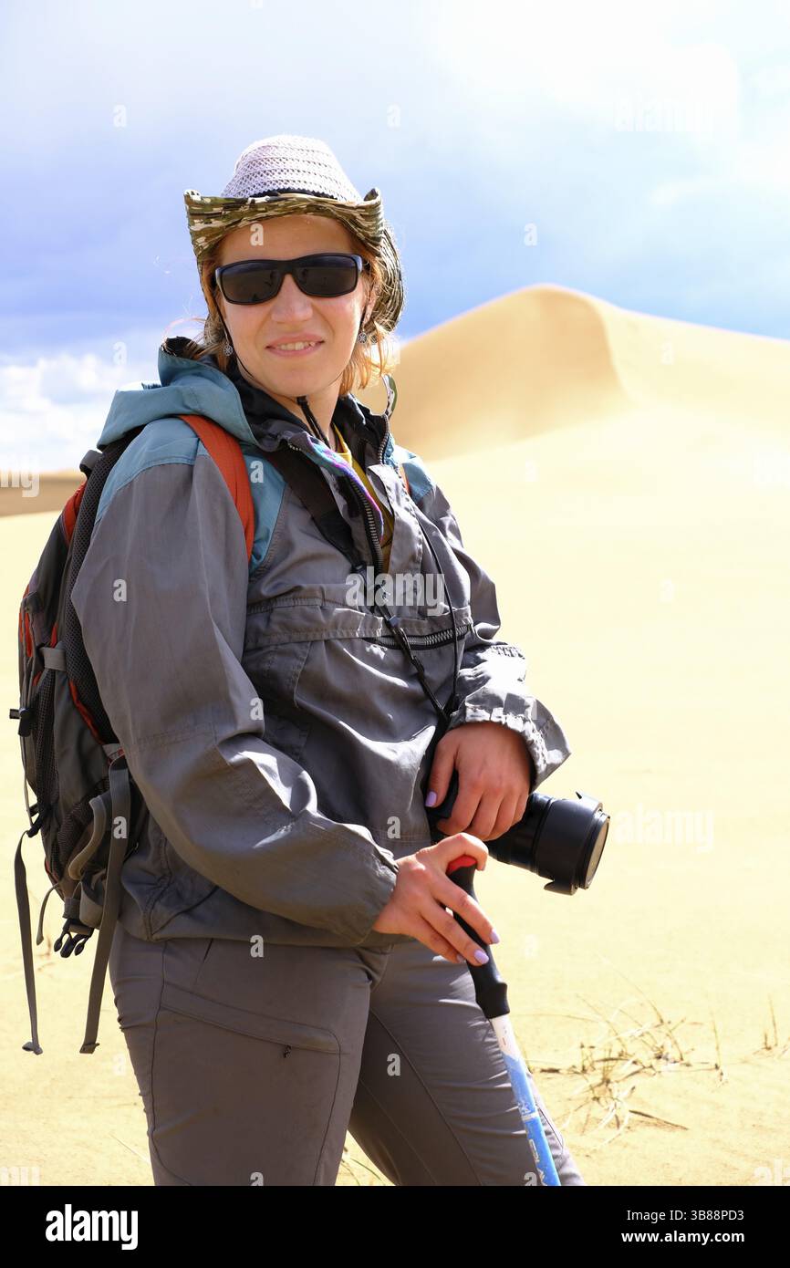 Tourist walking along the edge of the sand dune. Large barkhan in ...