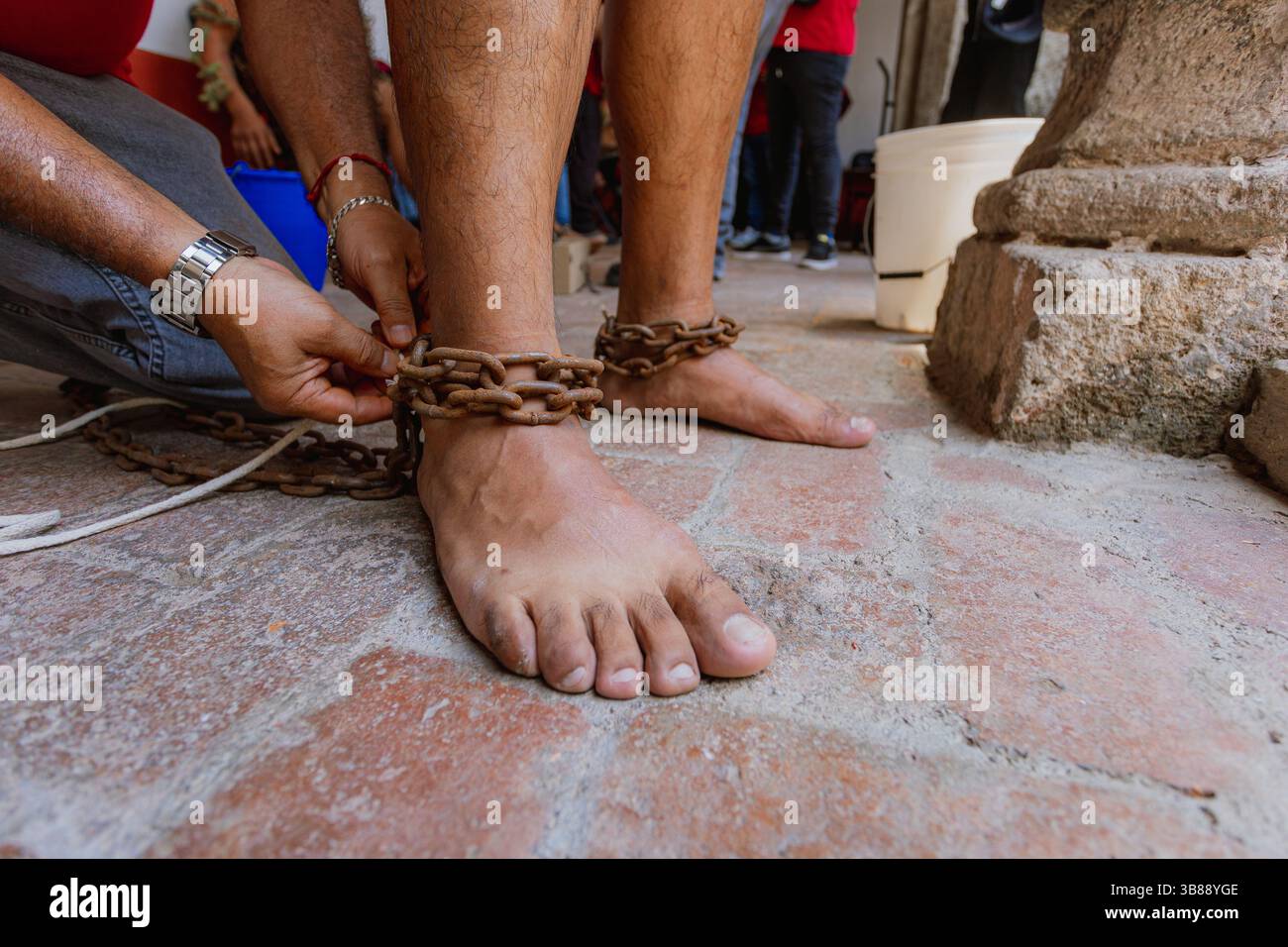 Close-up of feet being chained as part of the Engrillados tradition ...