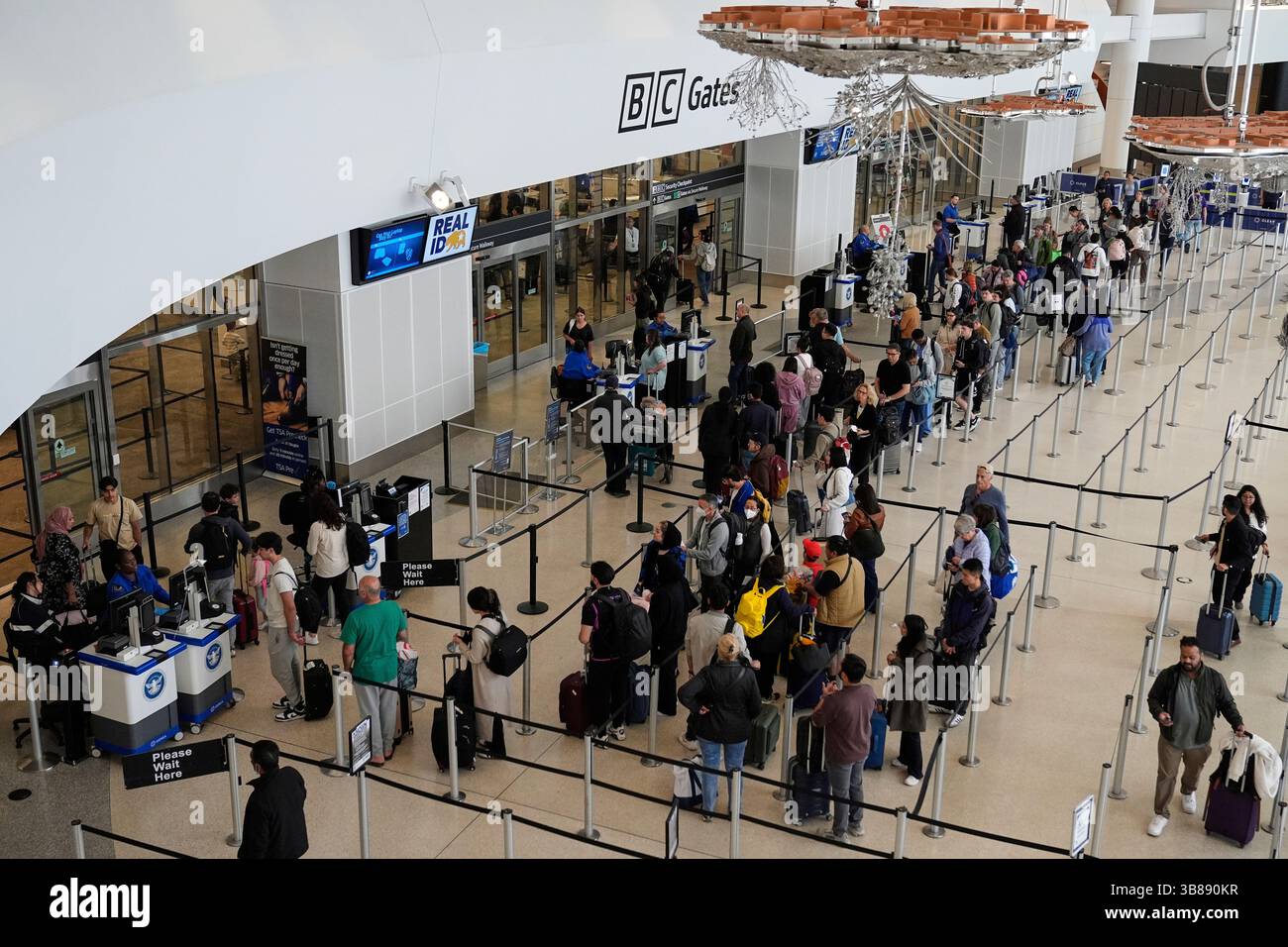 Travelers wait in a security checkpoint line at San Francisco ...