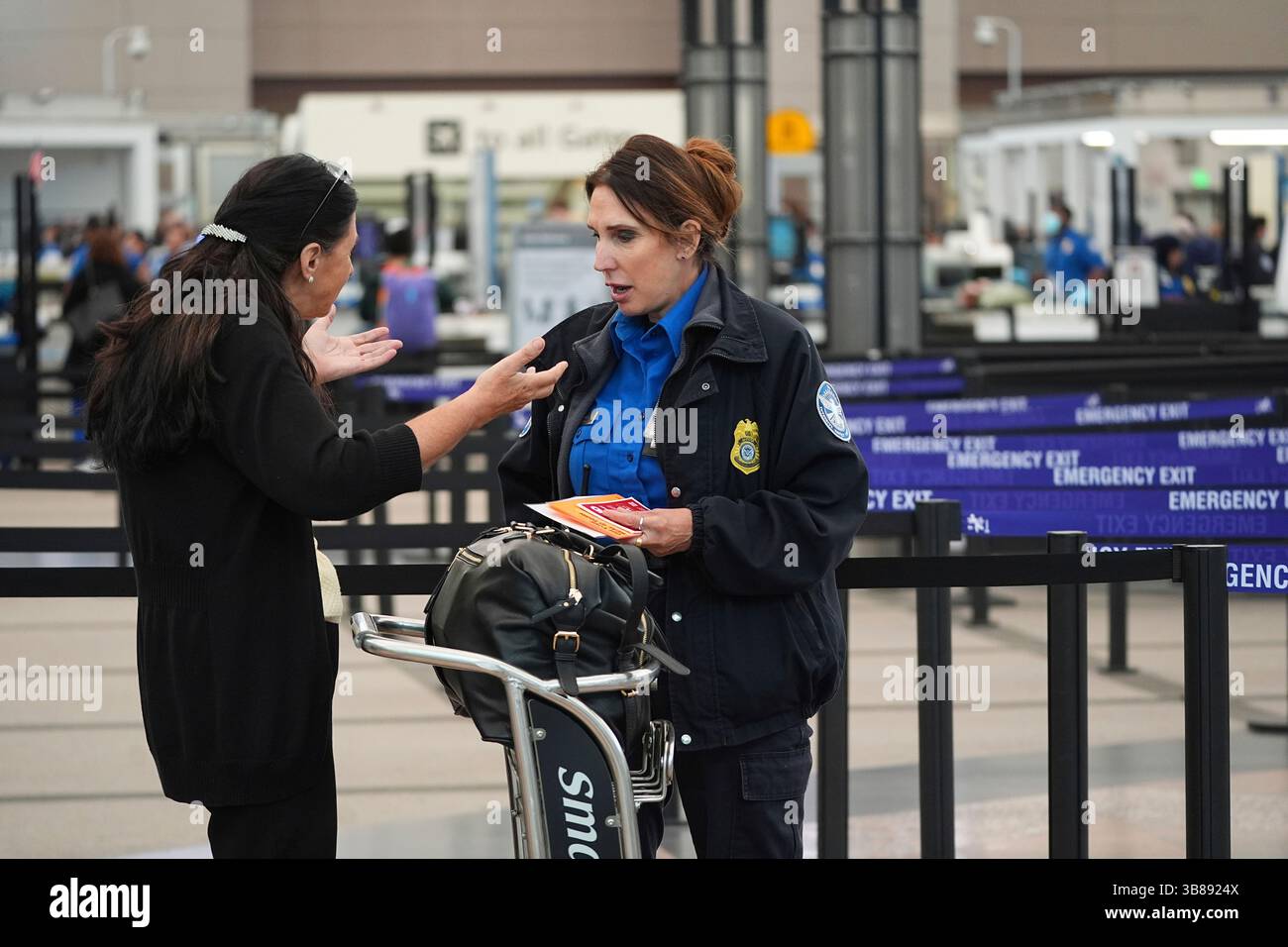 A TSA officer listens to a passenger as Real ID documents are required ...