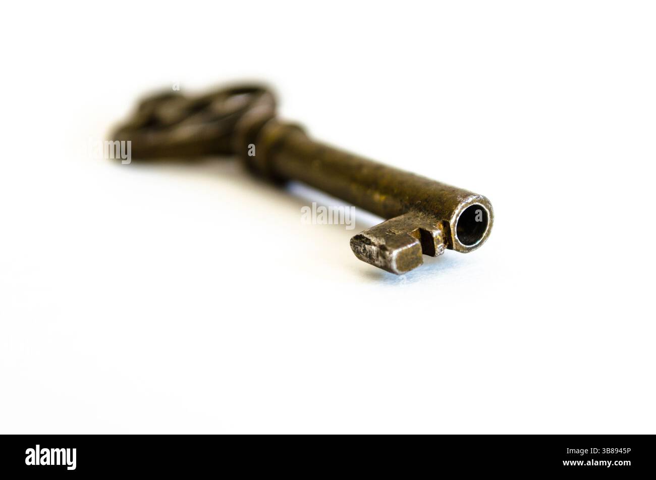Antique Brass Skeleton Key end on White Background, shown at an angled ...