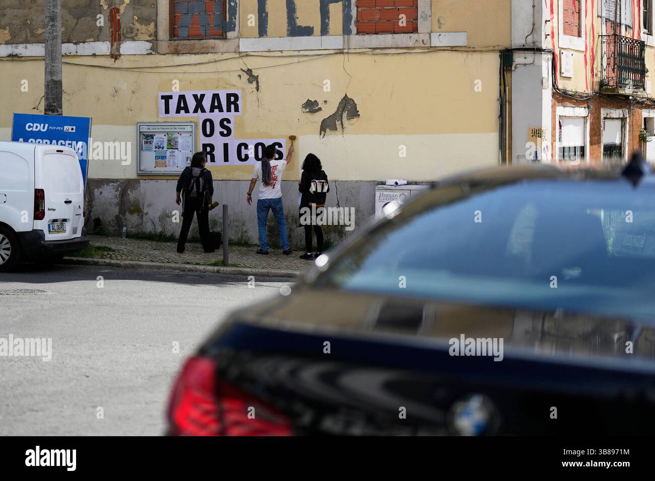 Militants of the Left Bloc political party paste posters with the ...
