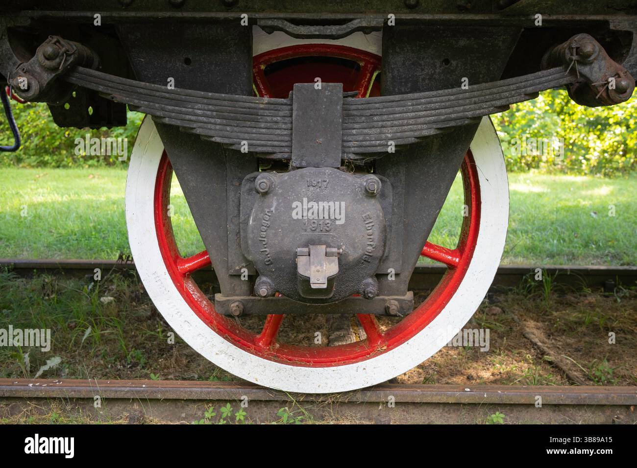 The wheel of a train is shown in detail, with the red and white spokes ...