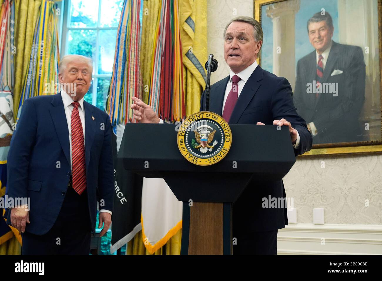 President Donald Trump listens after David Perdue was sworn in as U.S ...