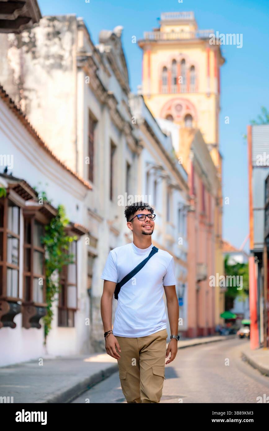Latino man wearing white t-shirt and beige pants walks confidently and ...