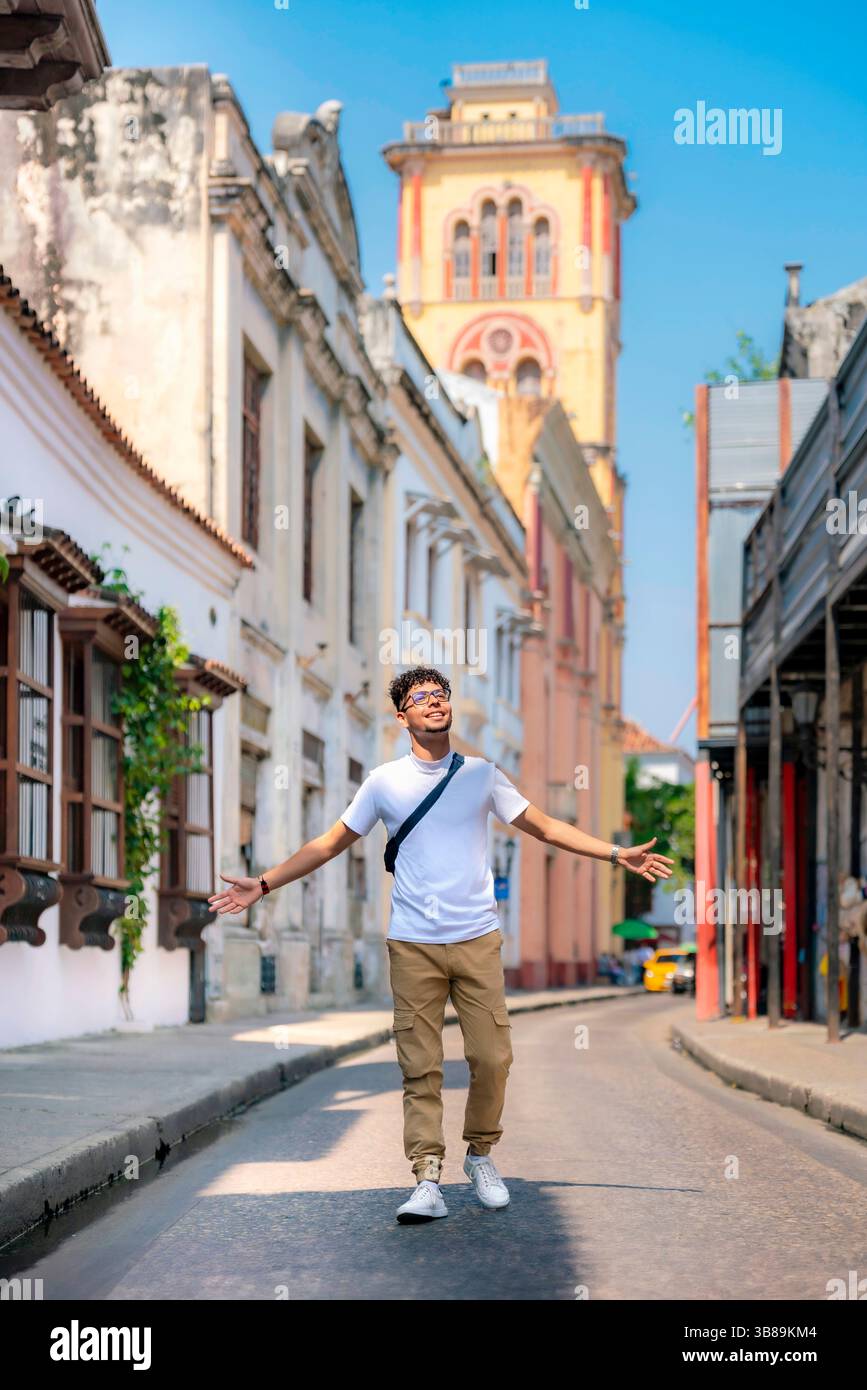 Latino man wearing white t-shirt and beige pants walks confidently and ...