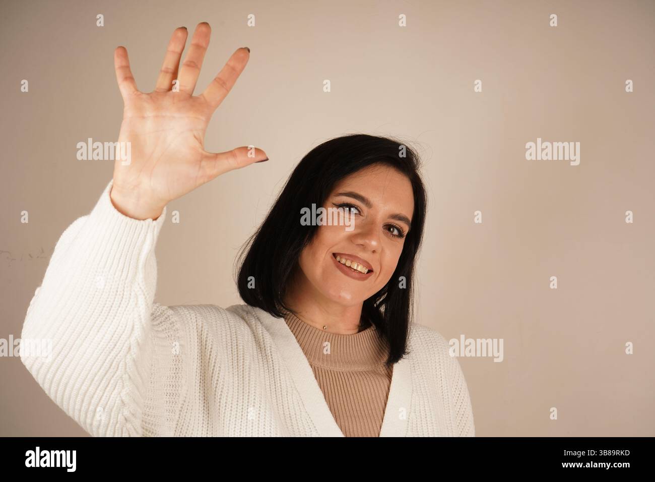 A single hand raised with an open palm delivers a clear "stop" signal ...