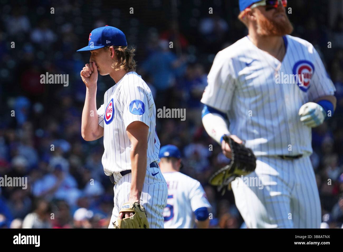 Chicago Cubs starting pitcher Ben Brown blows on his throwing hand ...