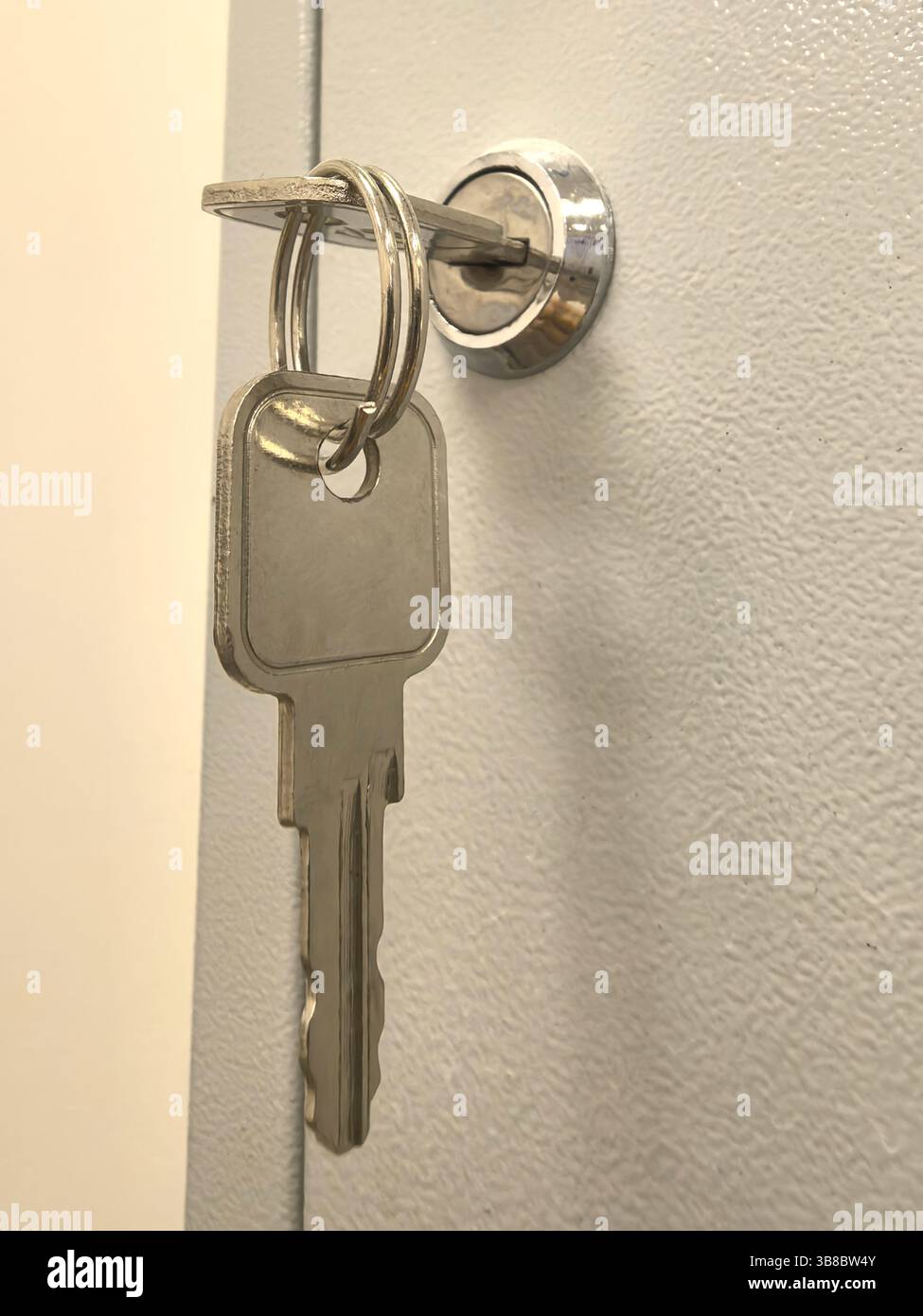 A silver key is inserted into a shiny lock, hinting at an open door ...