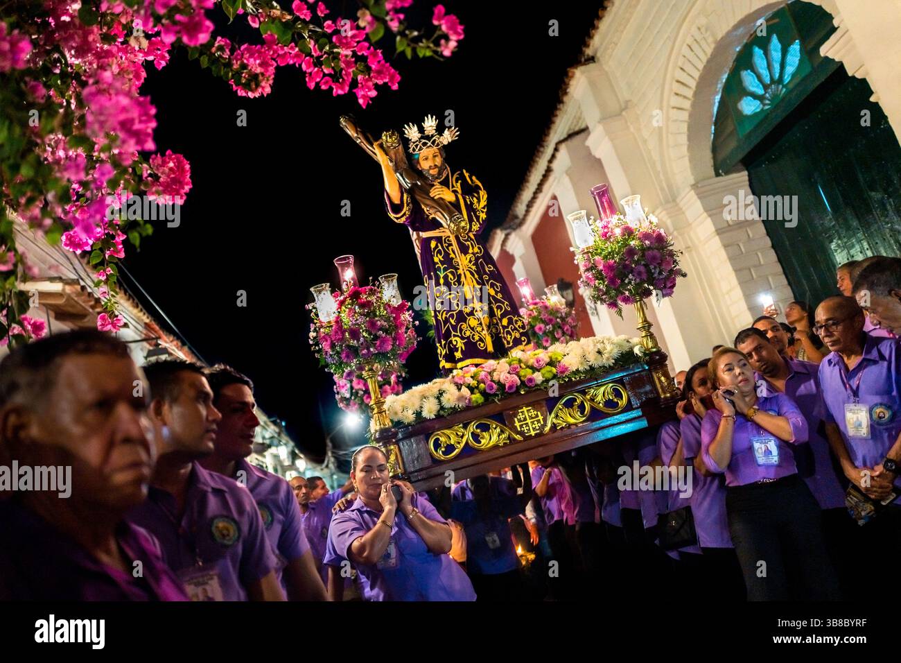 Catholic devotees, members of a religious brotherhood, carry a float ...
