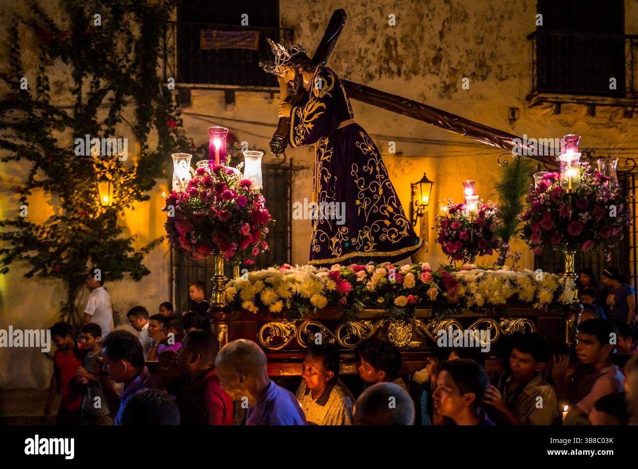 Catholic devotees, members of a religious brotherhood, carry a float ...