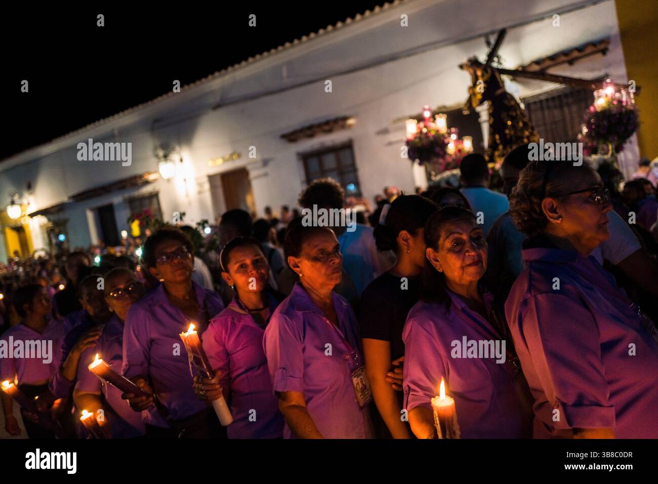 Female Catholic devotees, members of a religious brotherhood, carry lit ...