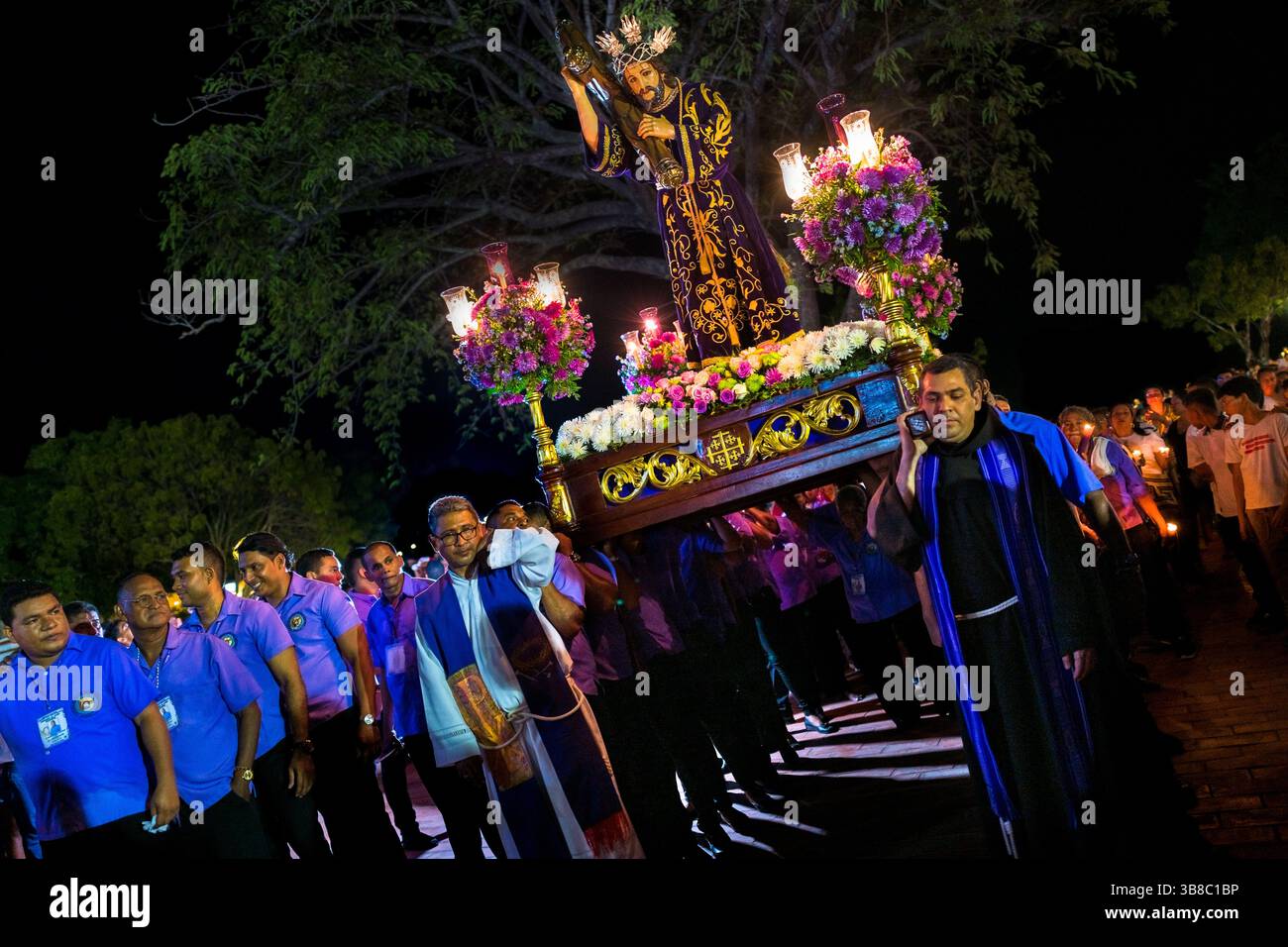 Catholic devotees, members of a religious brotherhood, carry a float ...