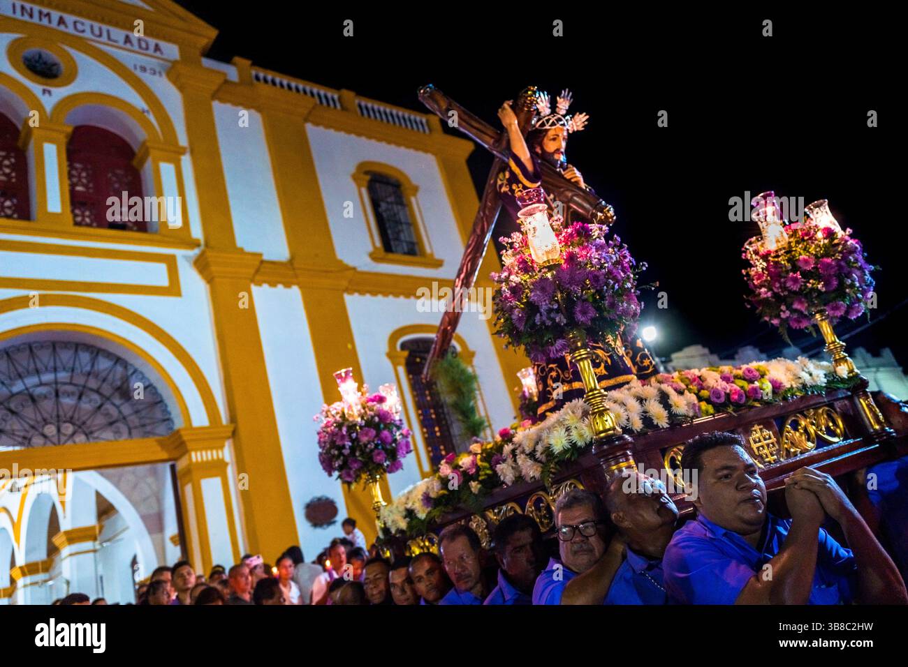 Catholic devotees, members of a religious brotherhood, carry a float ...