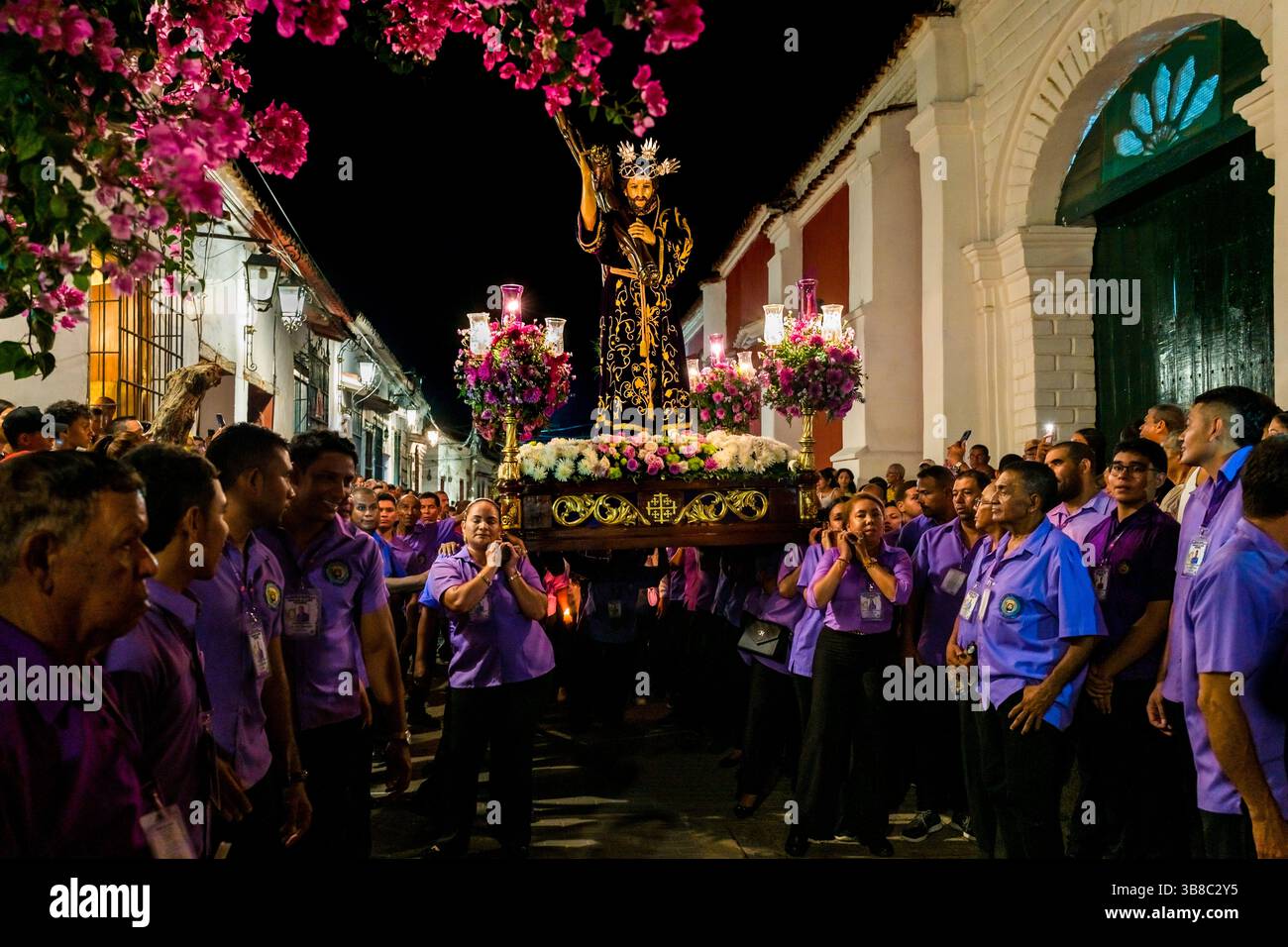 Catholic devotees, members of a religious brotherhood, carry a float ...