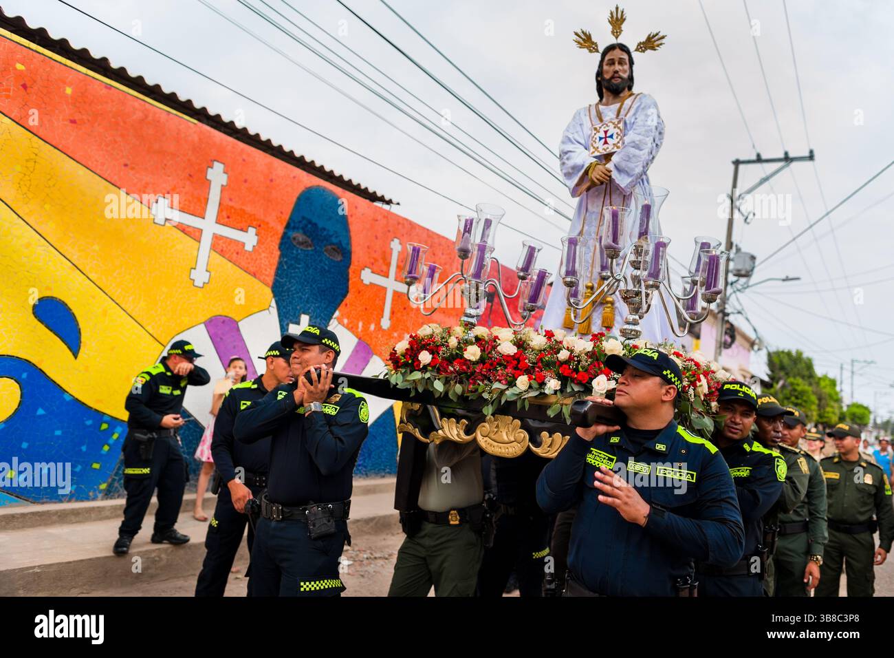 Members of the Colombian National Police carry a float (paso) depicting ...