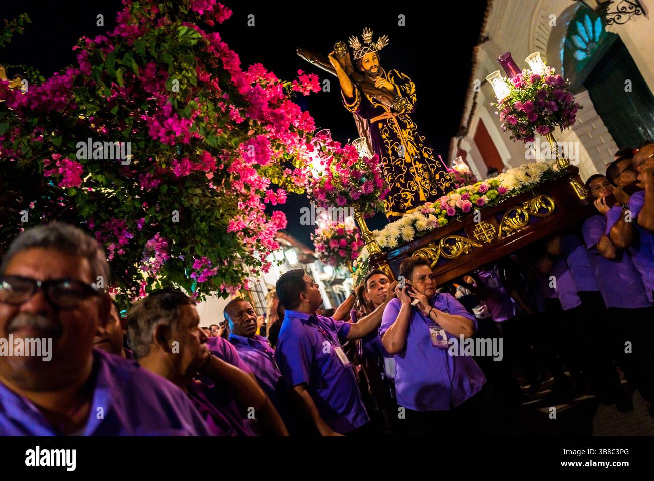 Catholic devotees, members of a religious brotherhood, carry a float ...