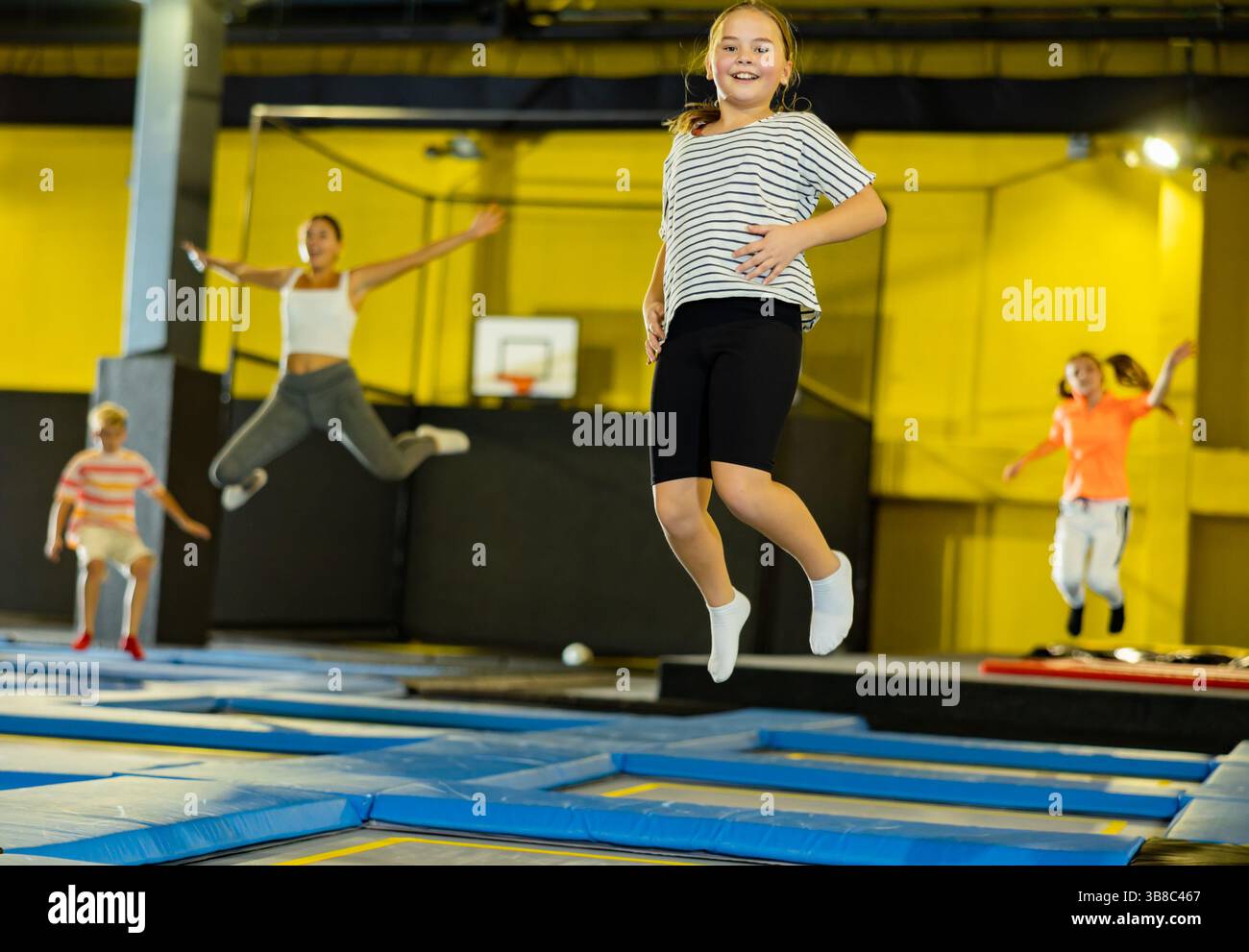 Tween girl having fun jumping in indoor trampoline arena Stock Photo ...