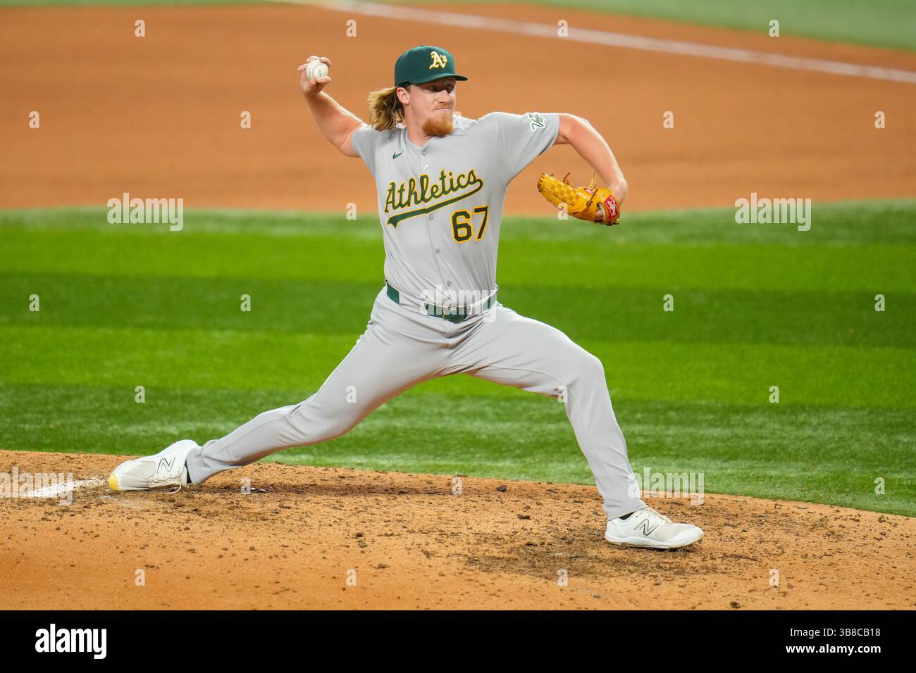 Athletics pitcher Grant Holman throws a pitch to the Texas Rangers ...