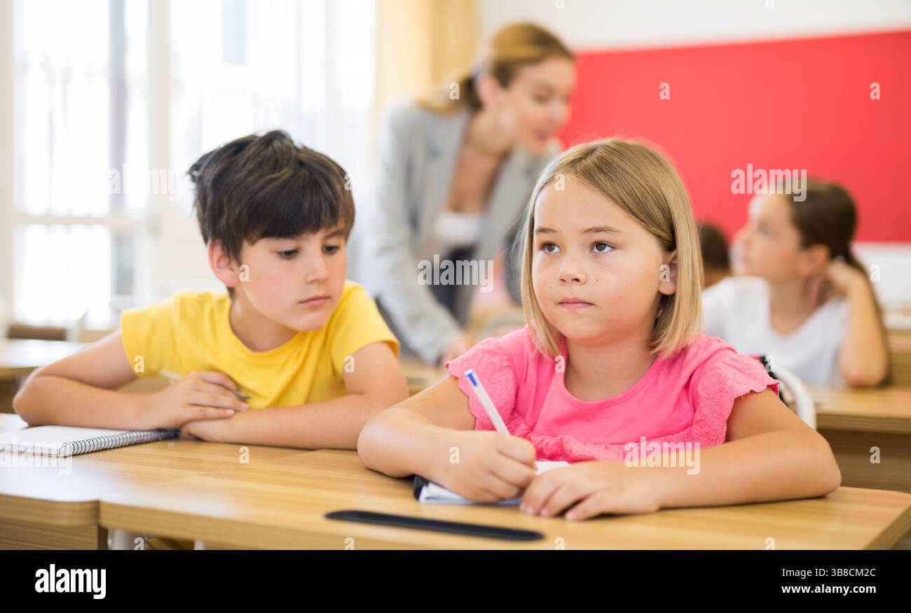 Kid cheating during test Stock Photo - Alamy